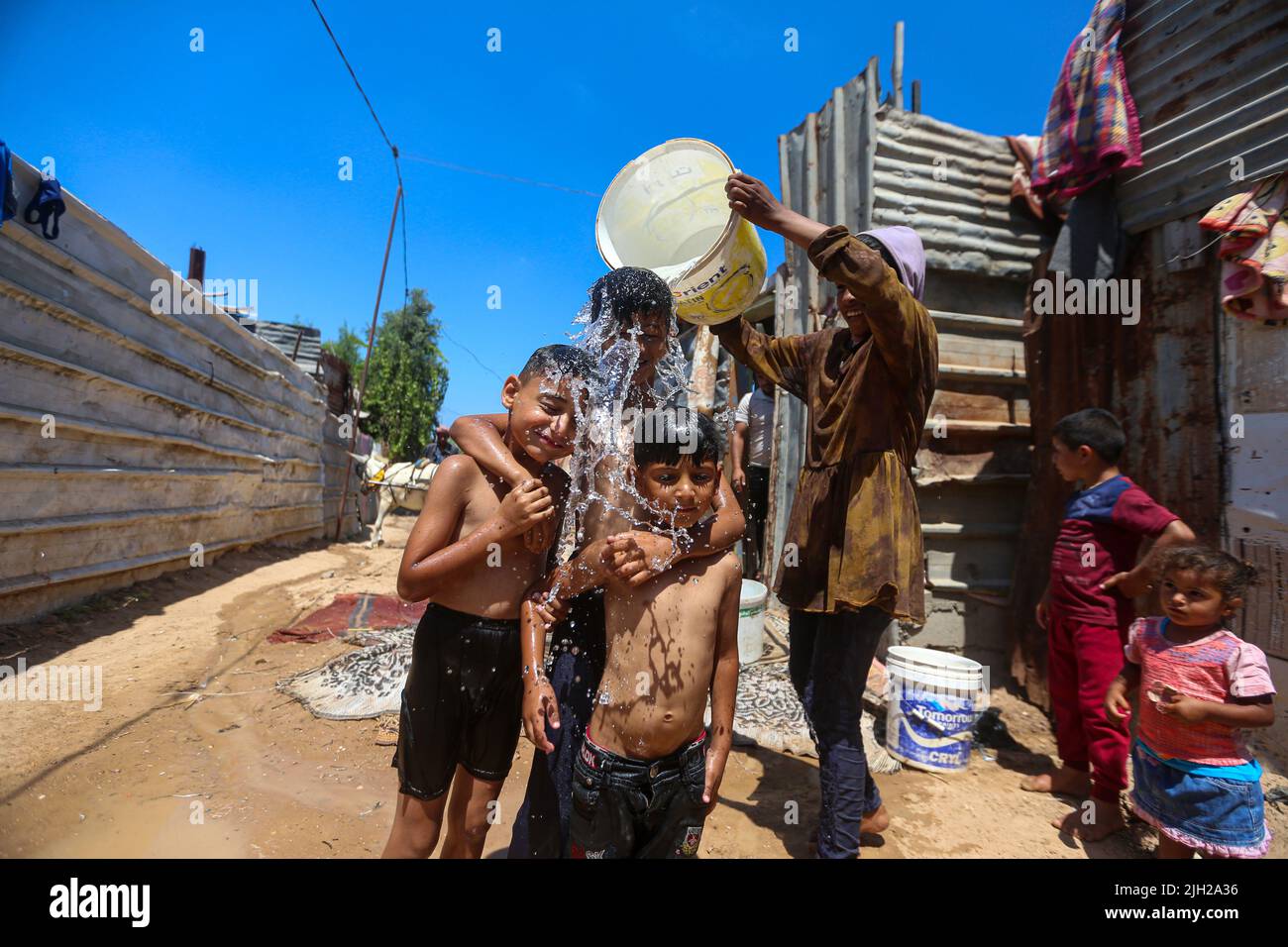 Gaza City, Palestine. 14th July 2022. A Palestinian mother showering ...