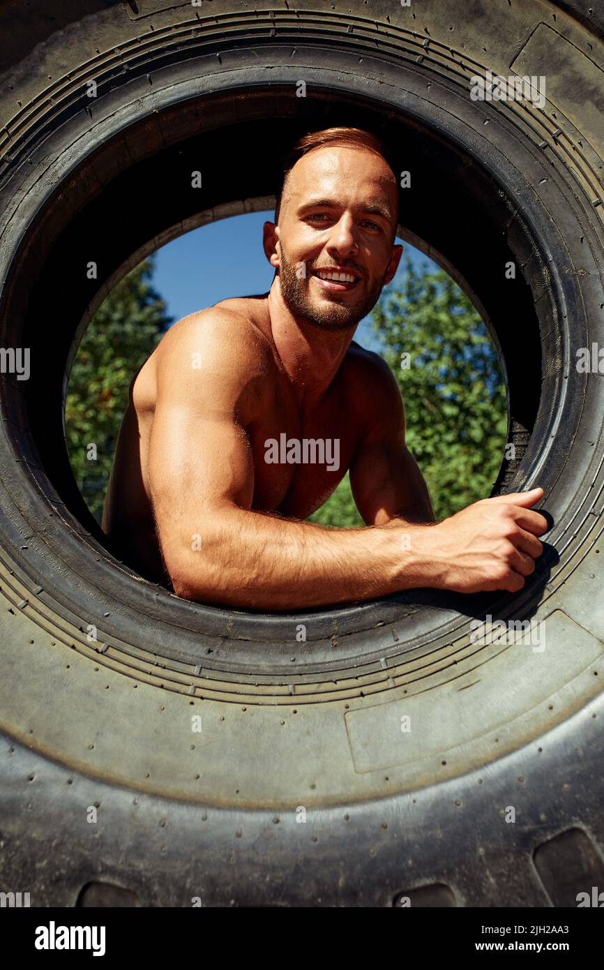 Strong man training workout lifting large tire outdoor gym. Sportive ...