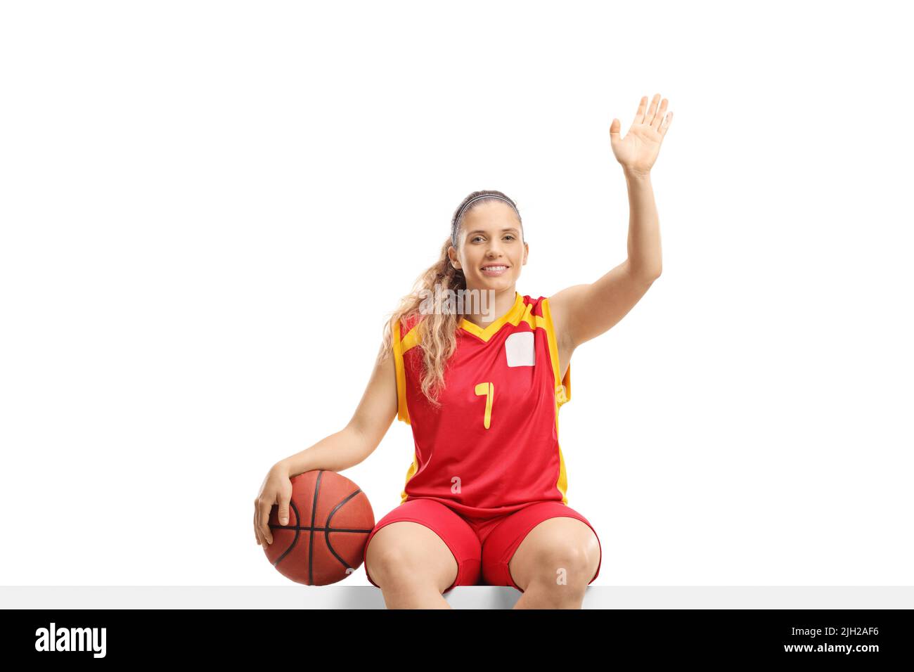 Female basketball player sitting on a panel and waving at the camera ...