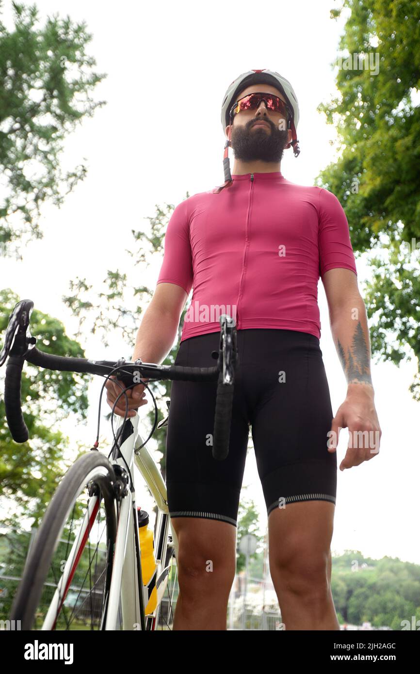 Strong Male cyclist in sportswear, glasses and protective helmet ...