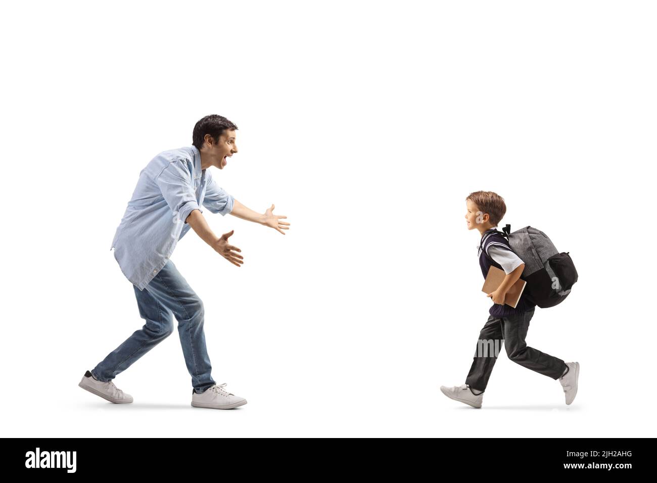 Full length profile shot of a schoolboy running to hug his father ...
