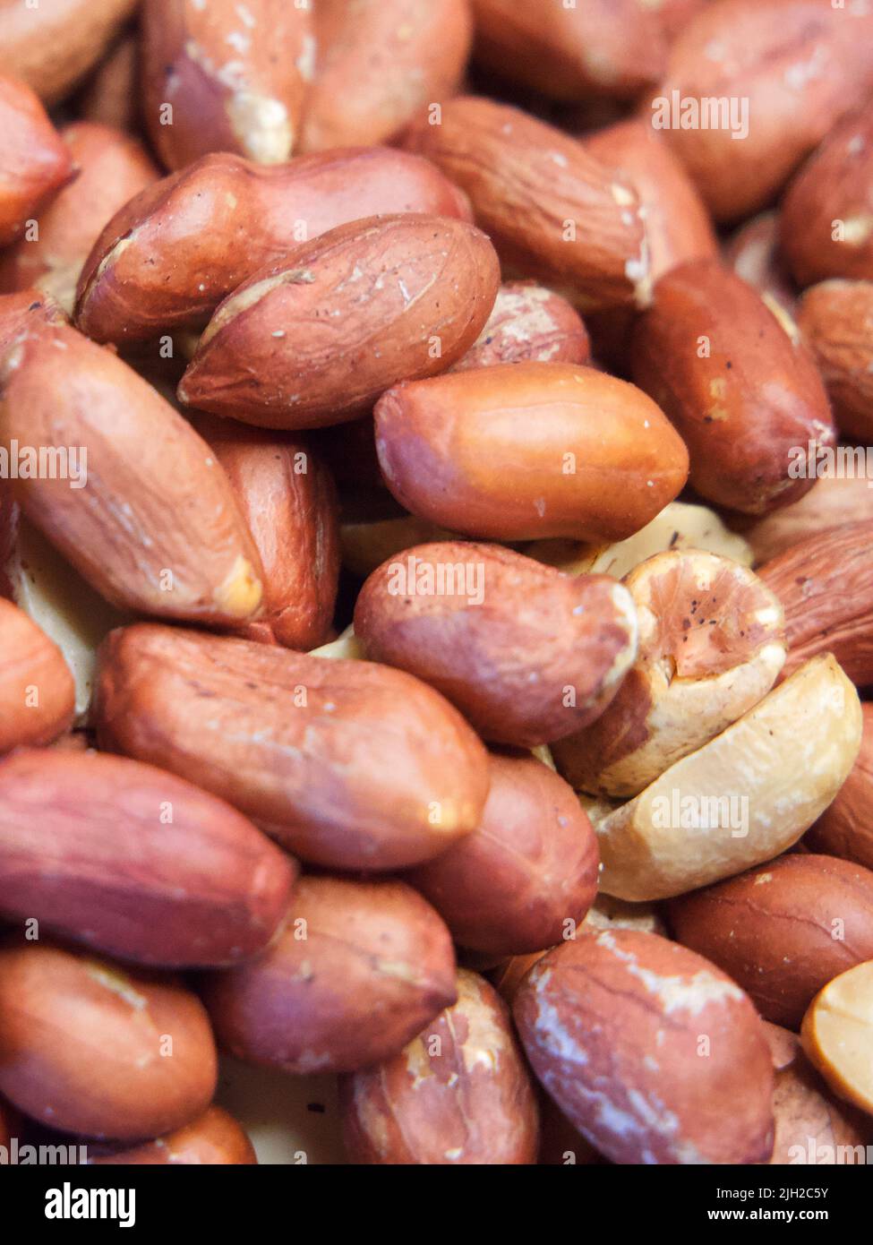 Roasted unpeeled peanuts macro, peanuts as a background. A lot of ...