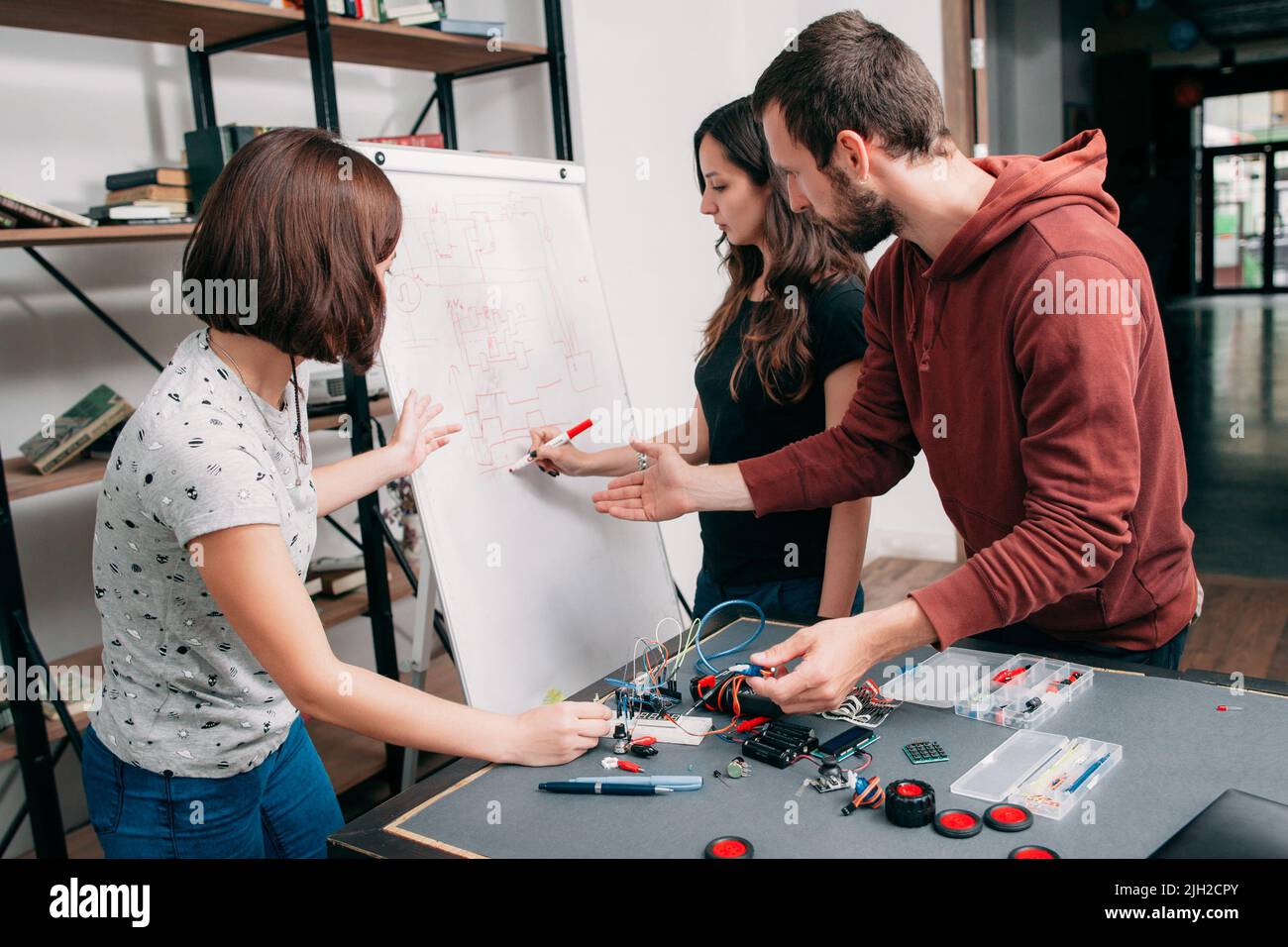 Young engineers discussing electronic scheme Stock Photo - Alamy