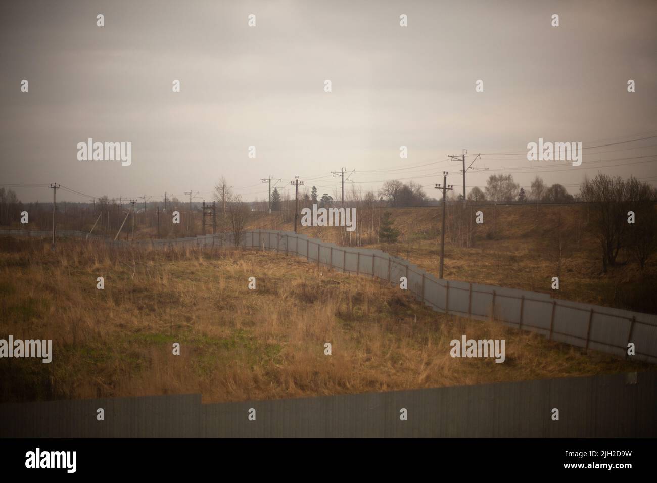 Fence in field. Fenced empty field. Steel fence is long Stock Photo - Alamy