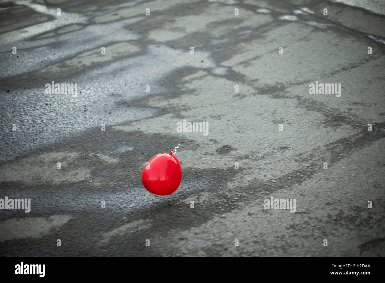 Red ball flies over asphalt. Balloon outside Stock Photo - Alamy