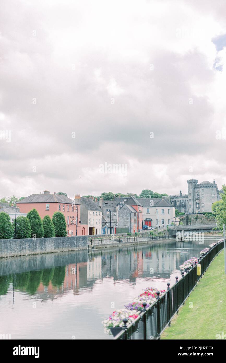 A view of the river, castle, and colorful homes in Kilkenny, Ireland ...