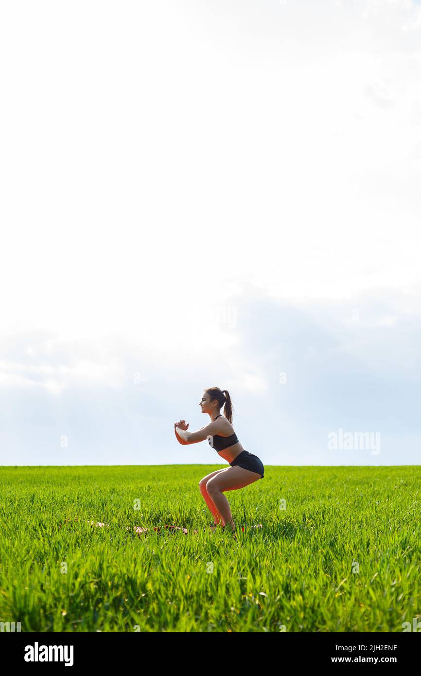 Girl athlete does squats in nature, exercises for the buttocks Stock ...