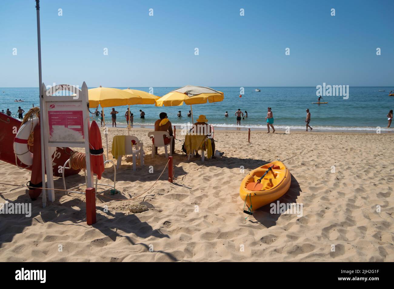Beach lifeguards watching the ocean with a kayak near, and liguard gear ...