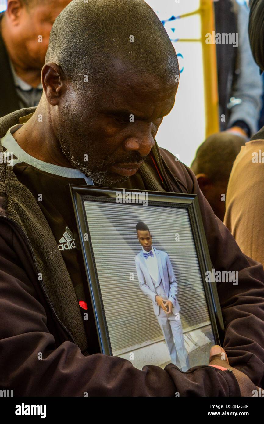 SOWETO, SOUTH AFRICA – JULY 14: A Man holdson to a picture of a ...