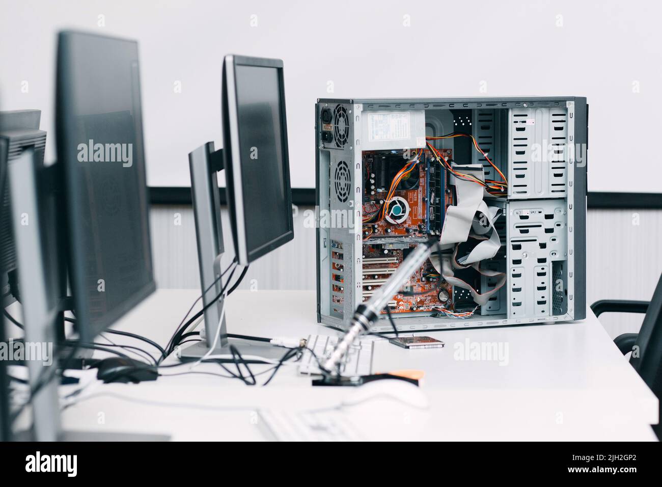 Disassembled computer unit on table with monitors Stock Photo - Alamy