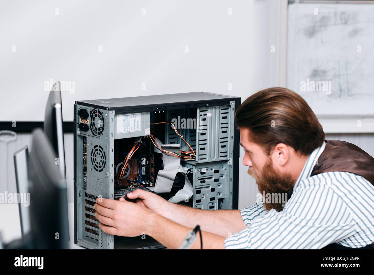 Bearded repairman disassembling computer unit Stock Photo - Alamy