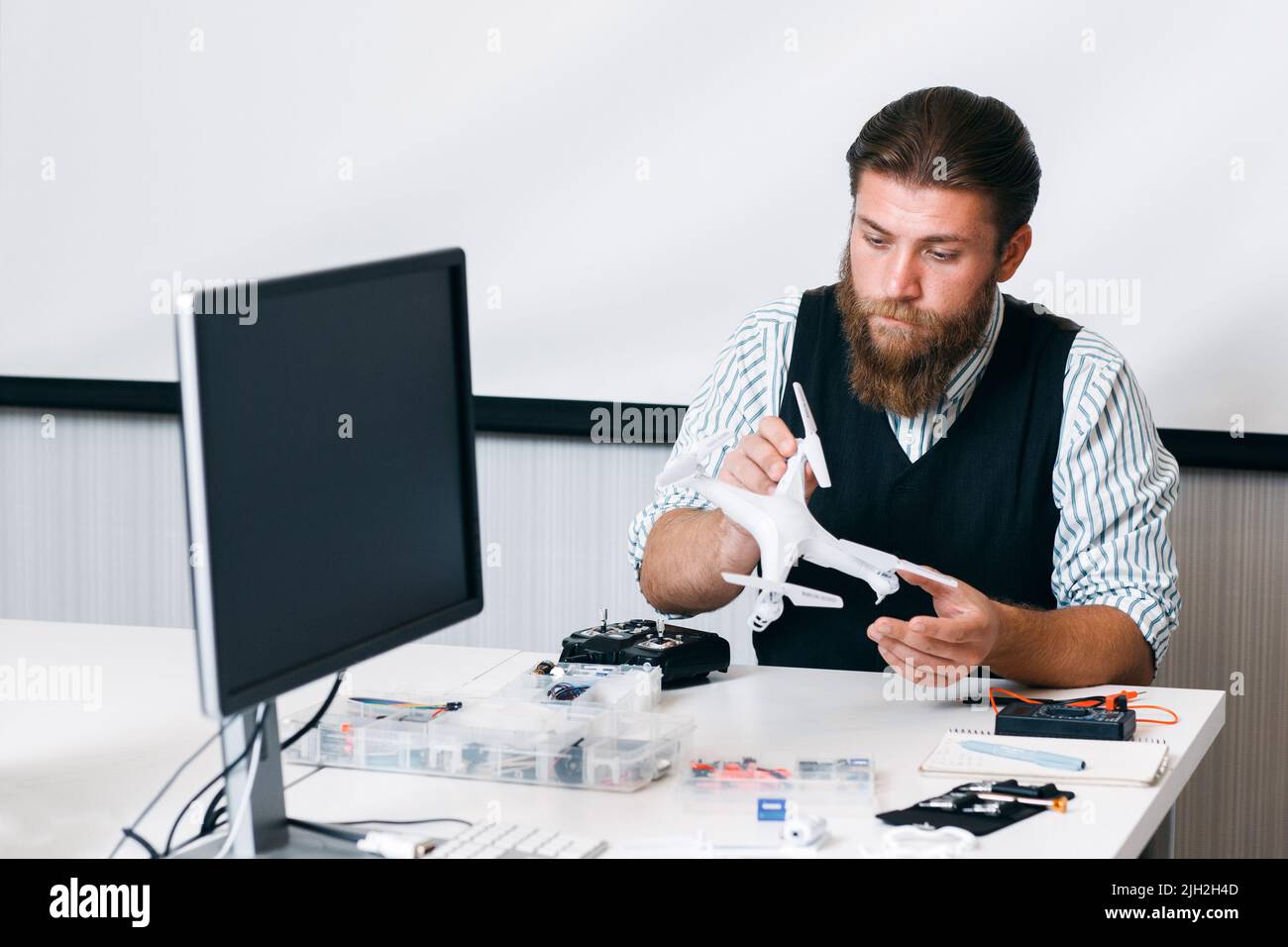 Engineer constructing drone in office, front view Stock Photo - Alamy