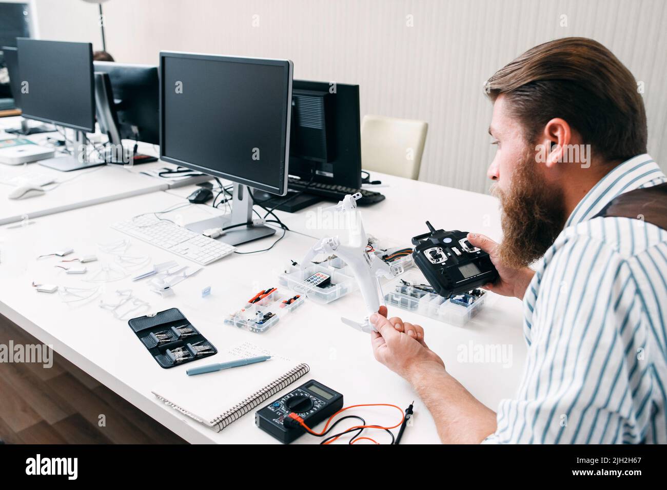 Office worker assembling drone at work Stock Photo - Alamy