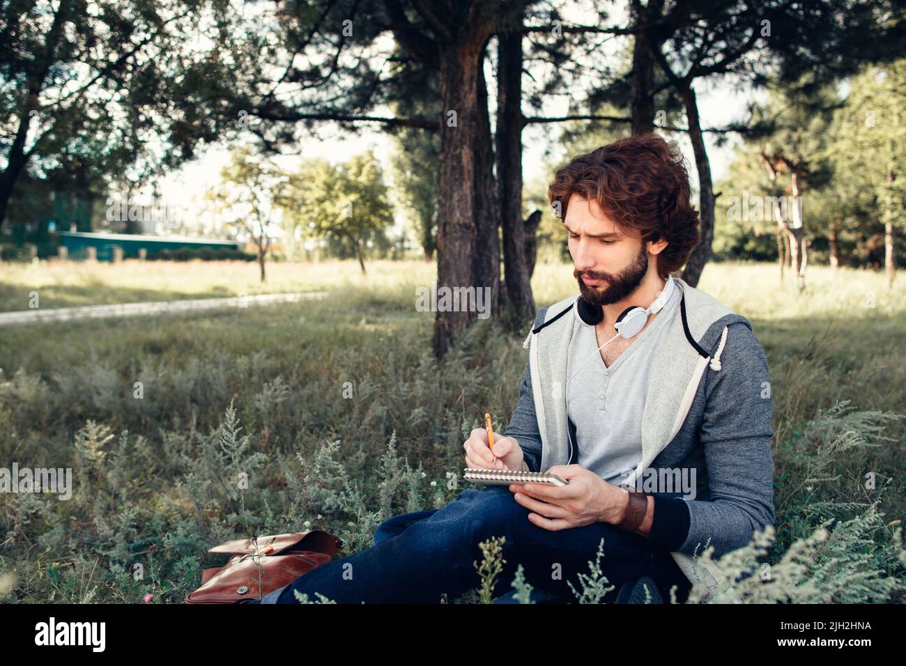 Man writing in copybook at nature, free space Stock Photo - Alamy