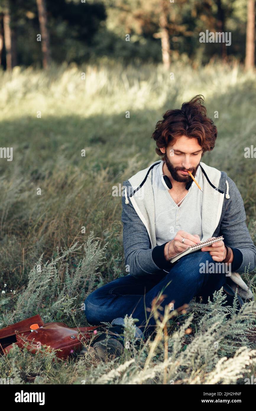 Artist sketching in notebook outdoor, free space Stock Photo - Alamy