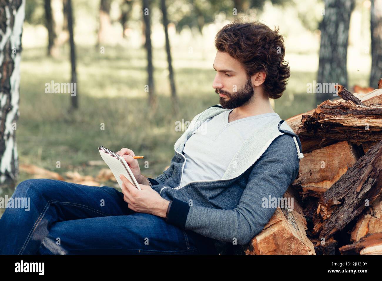 Artist drawing landscape in notebook, side view Stock Photo - Alamy