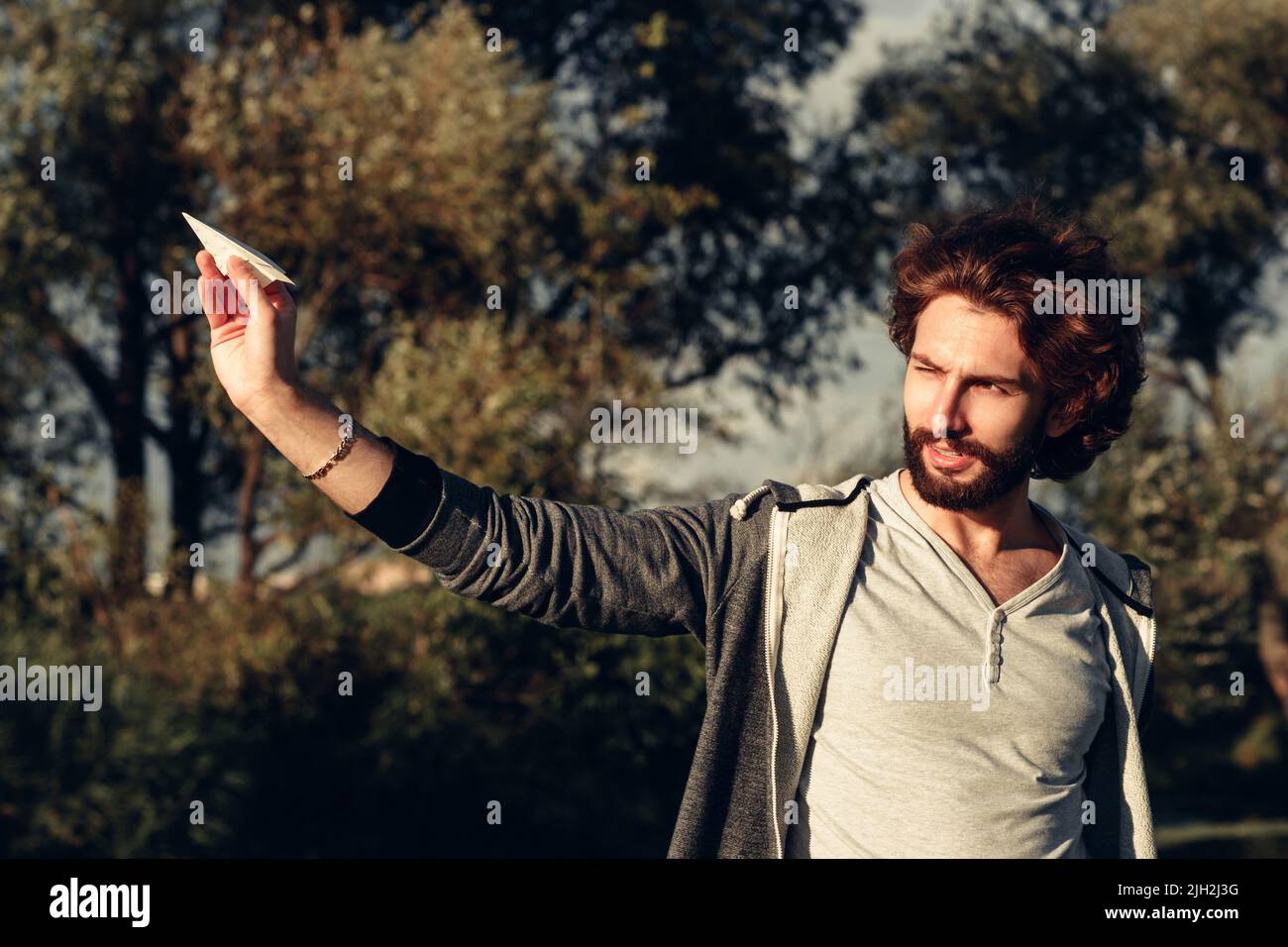 Man launching paper airplane at nature free space Stock Photo - Alamy