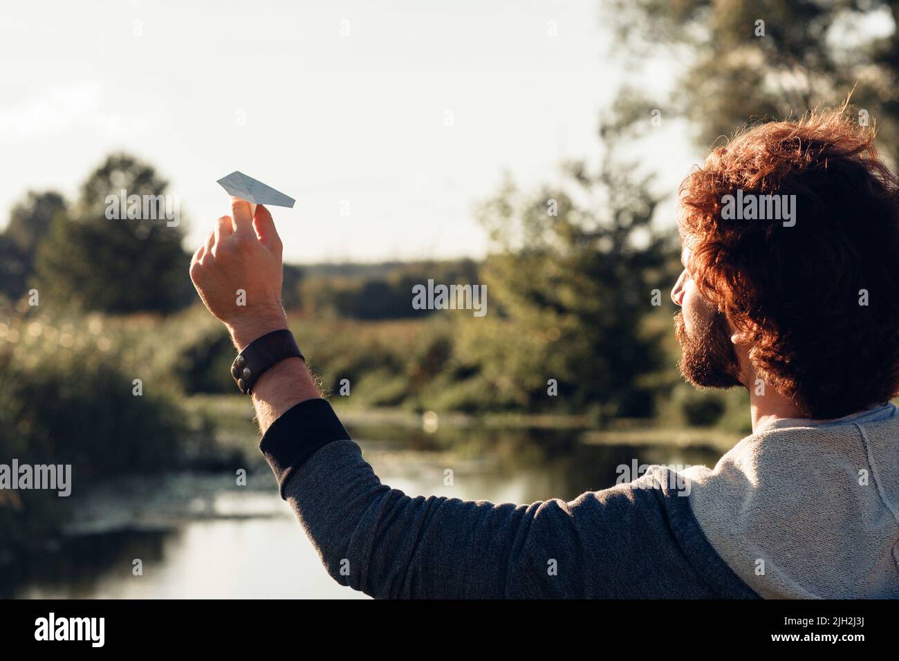 Man running paper airplane to river back view Stock Photo - Alamy