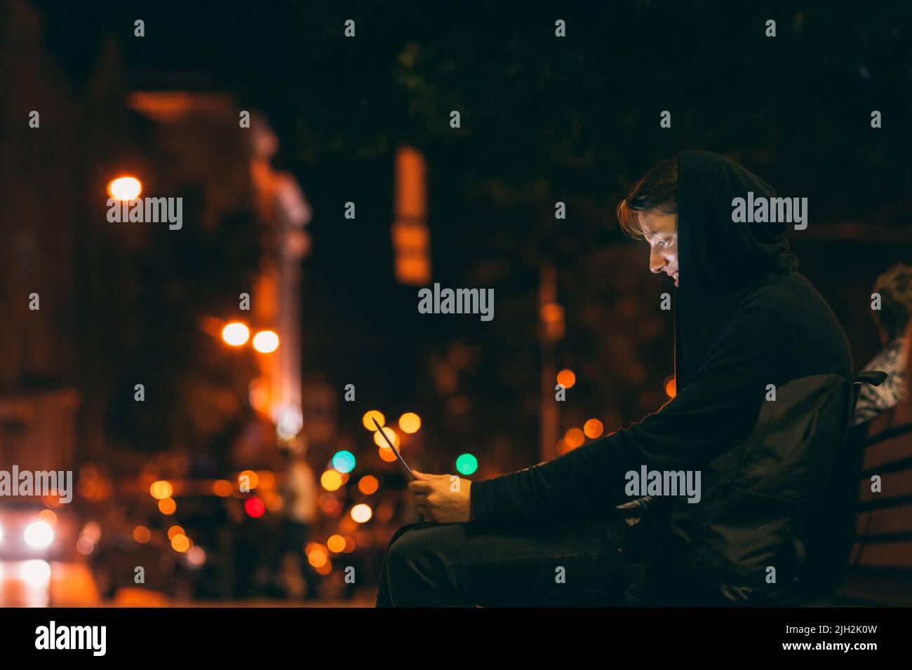 Hooded man chatting with laptop in night Stock Photo - Alamy