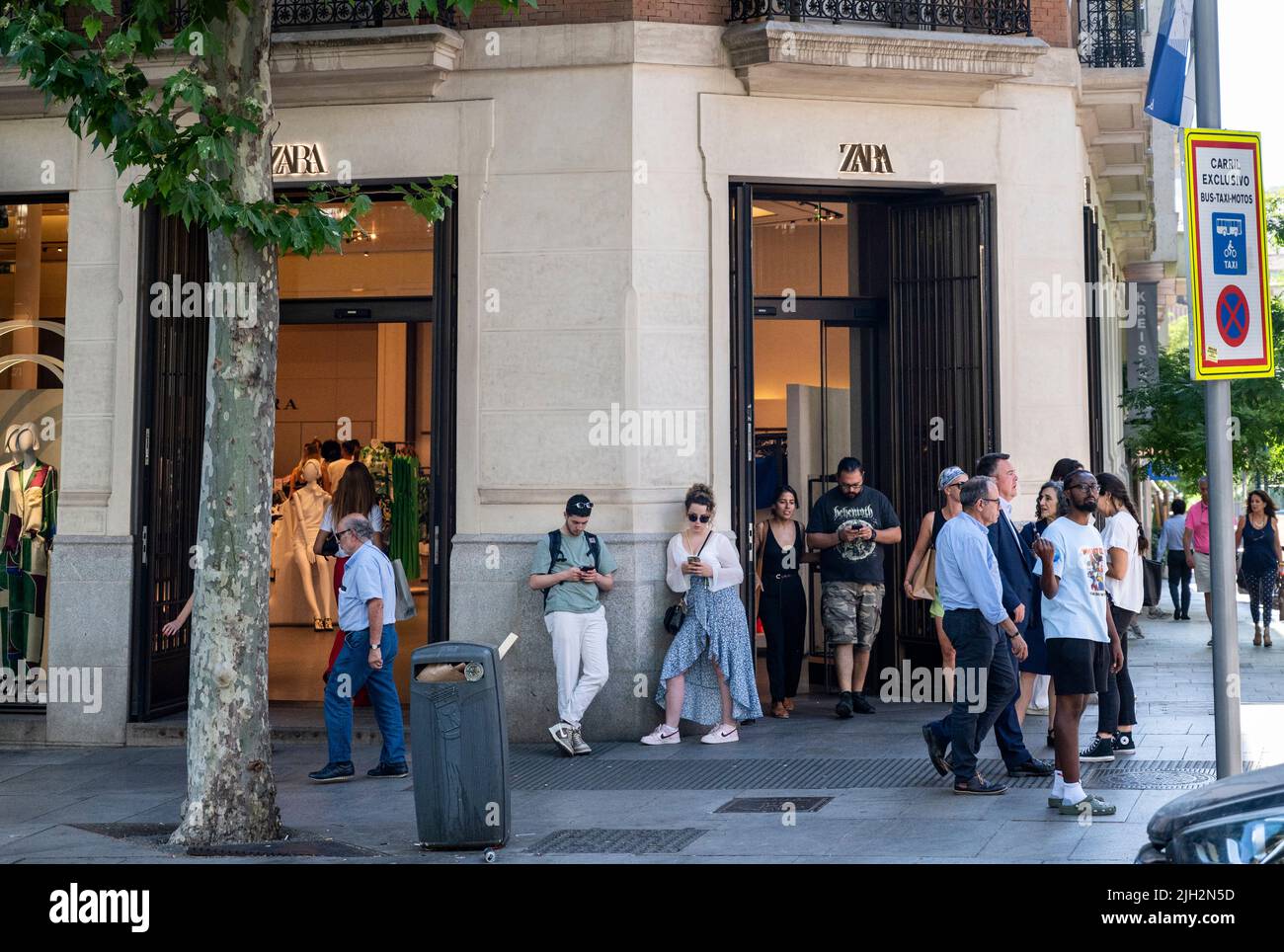 Pedestrians walk past the Spanish multinational clothing design retail ...