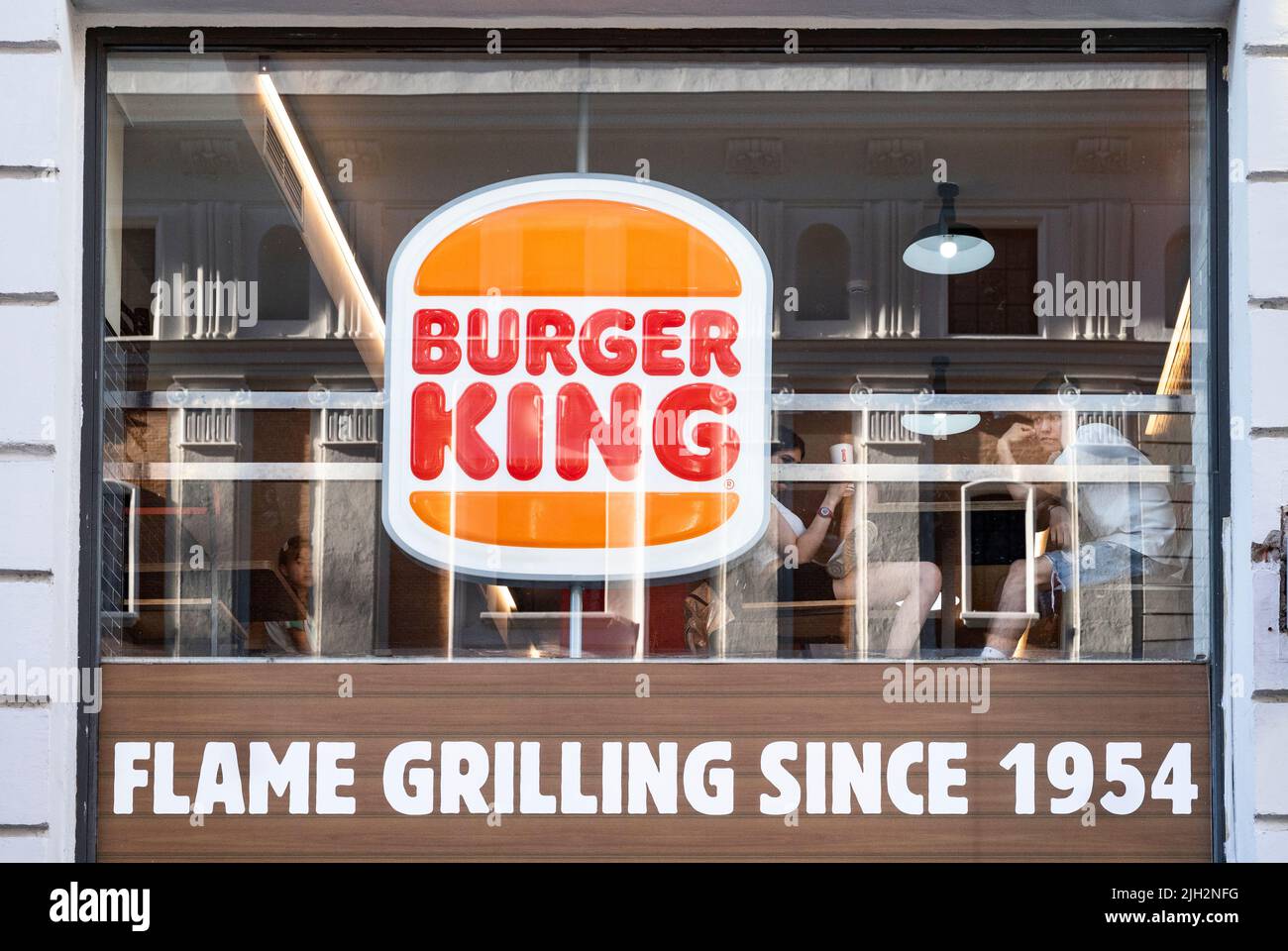 Customers eat at the American chain of hamburger fast food restaurants ...