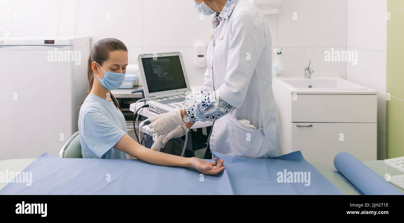 Doctor doing the ultrasound on the hand close up. Doctor demonstrates ...