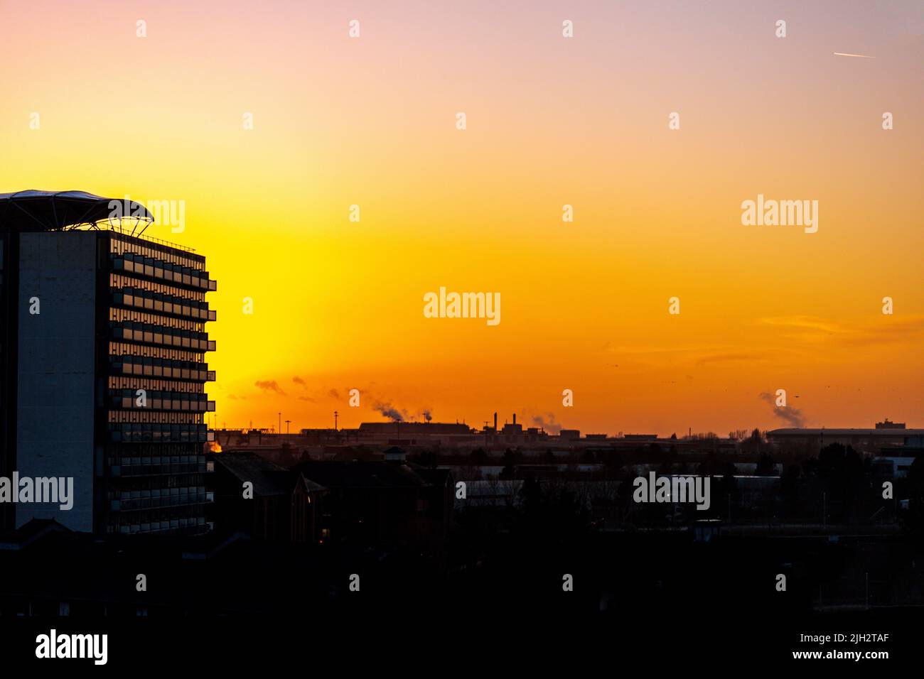 A beautiful orange sunset with modern style buildings in view, taken on ...