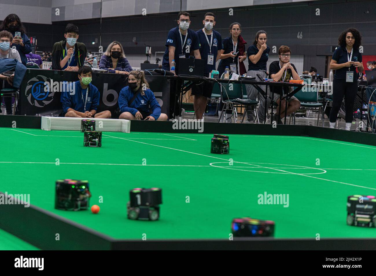 Team members watch their robots in action during a match in the small ...