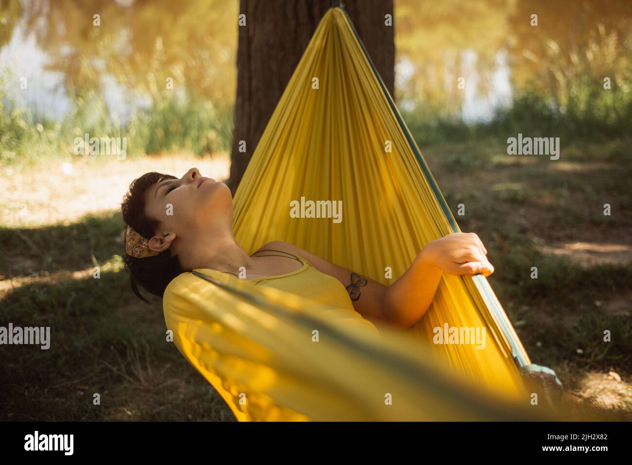 Pretty girl is sleeping on a hammock in the central park Stock Photo ...