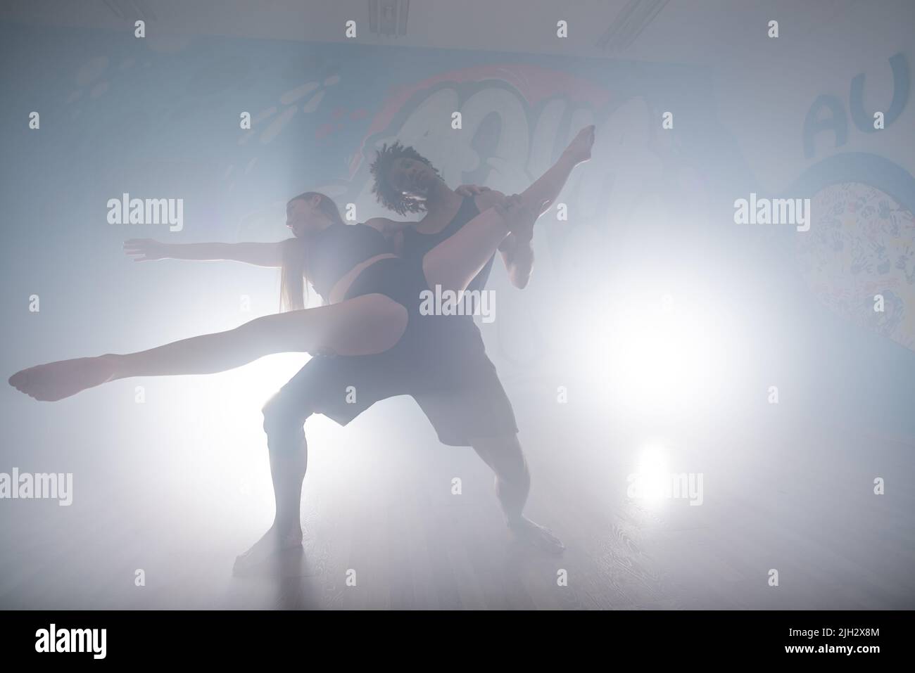 Group of multiracial dancers enjoying funky hip hop moves in dark ...