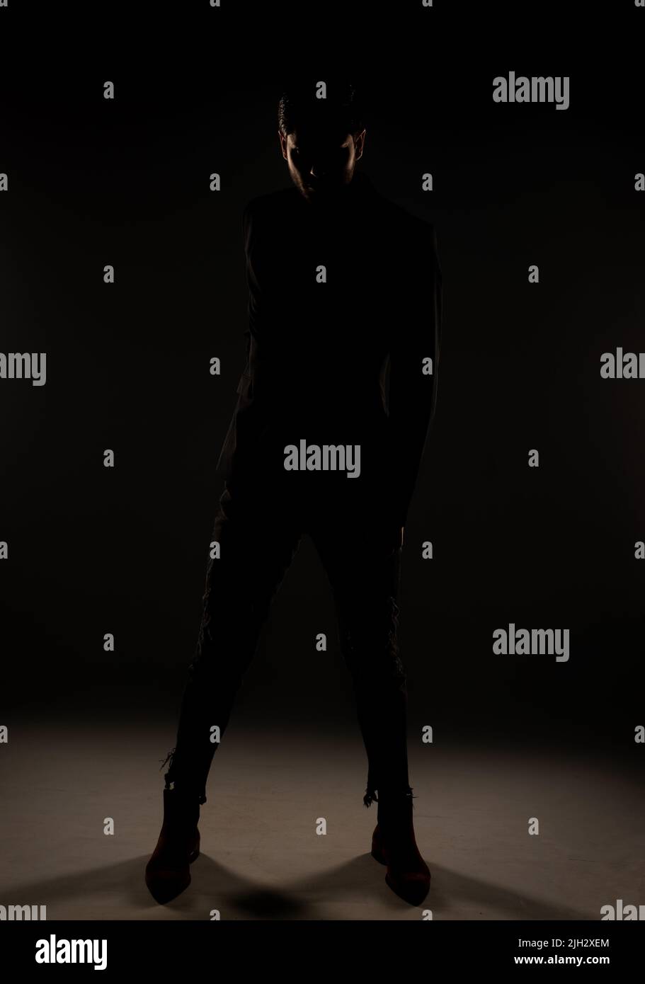 Tall attractive male in the studio posing for the camera with a ...