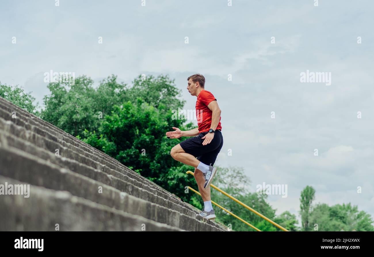 Fit male athlete performing stairs workout, running up climbing stairs ...