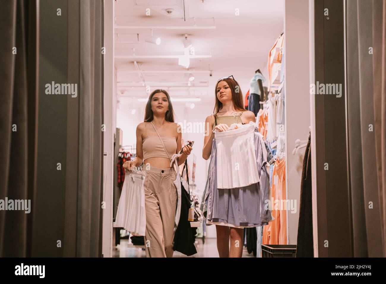 Two teenage girls going in to the changeing room in the shop Stock ...