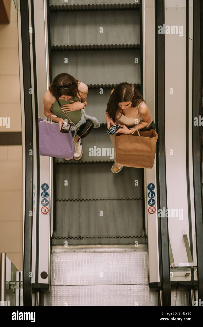 Two people going down escalator hi-res stock photography and images - Alamy