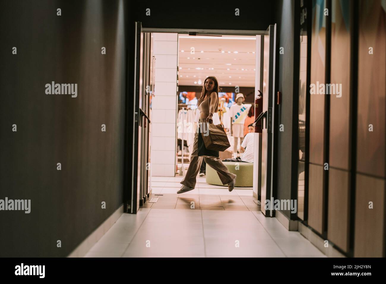 Cute girl with her shopping bags jumping in the mall Stock Photo - Alamy