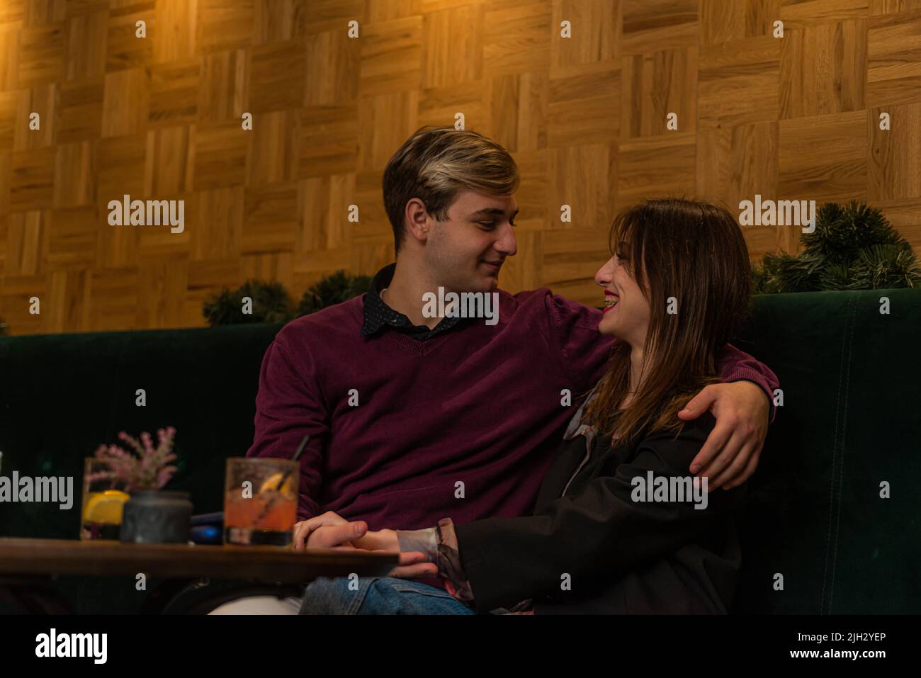 Amazing and adorable couple is hugging and smiling while looking each ...
