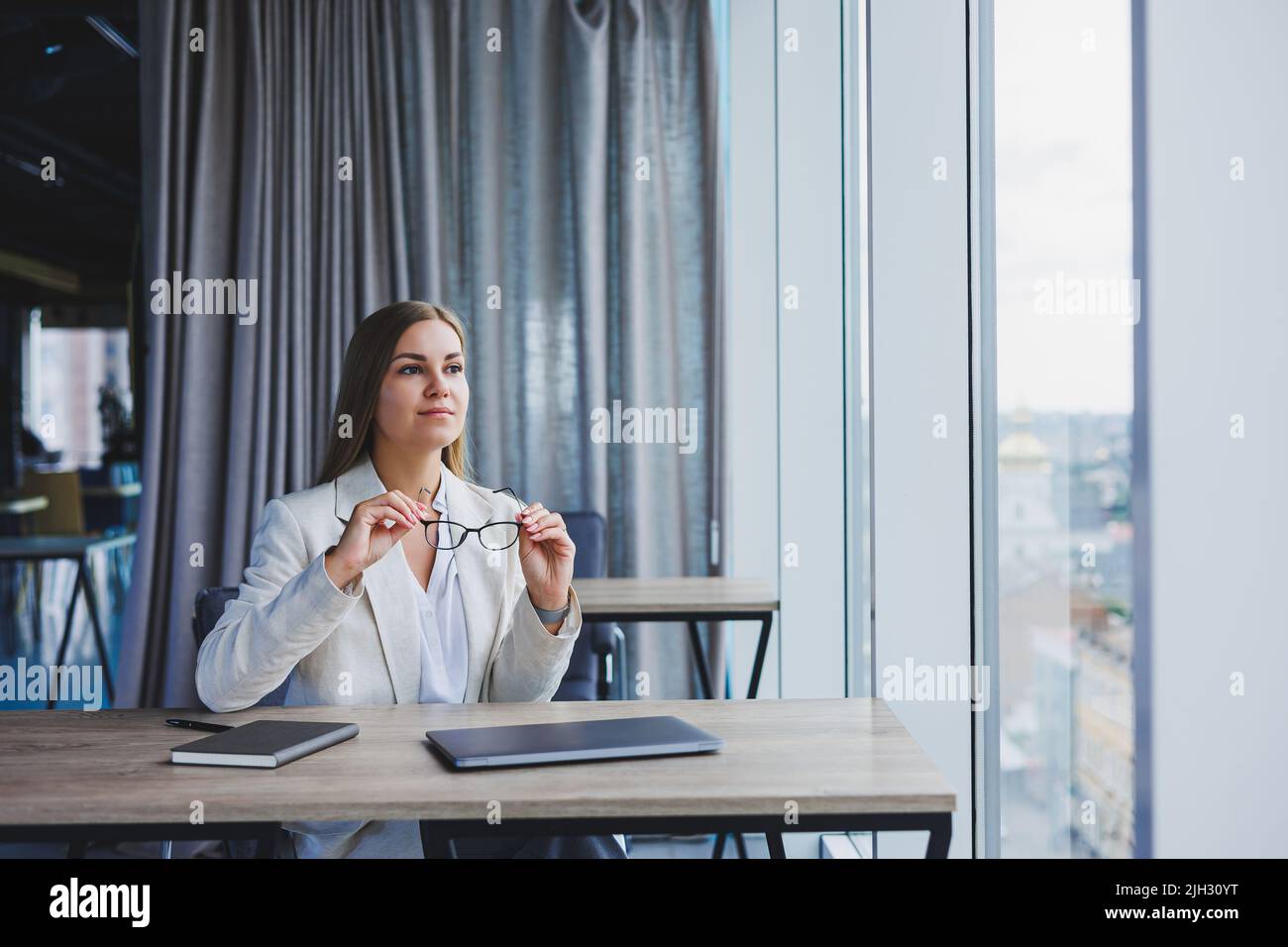 Successful young female manager in an elegant casual jacket and optical ...