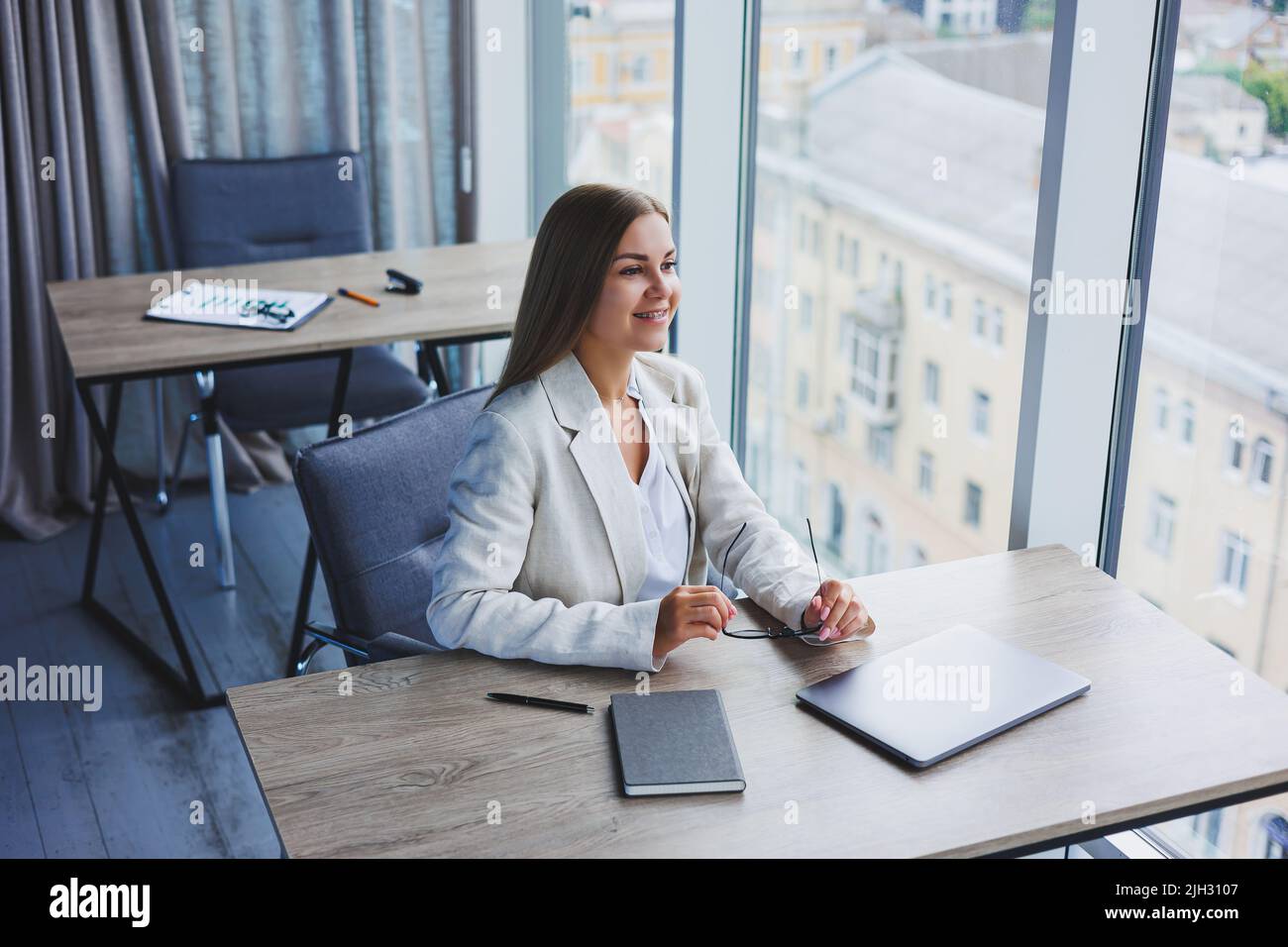 Successful young female manager in an elegant casual jacket and optical ...