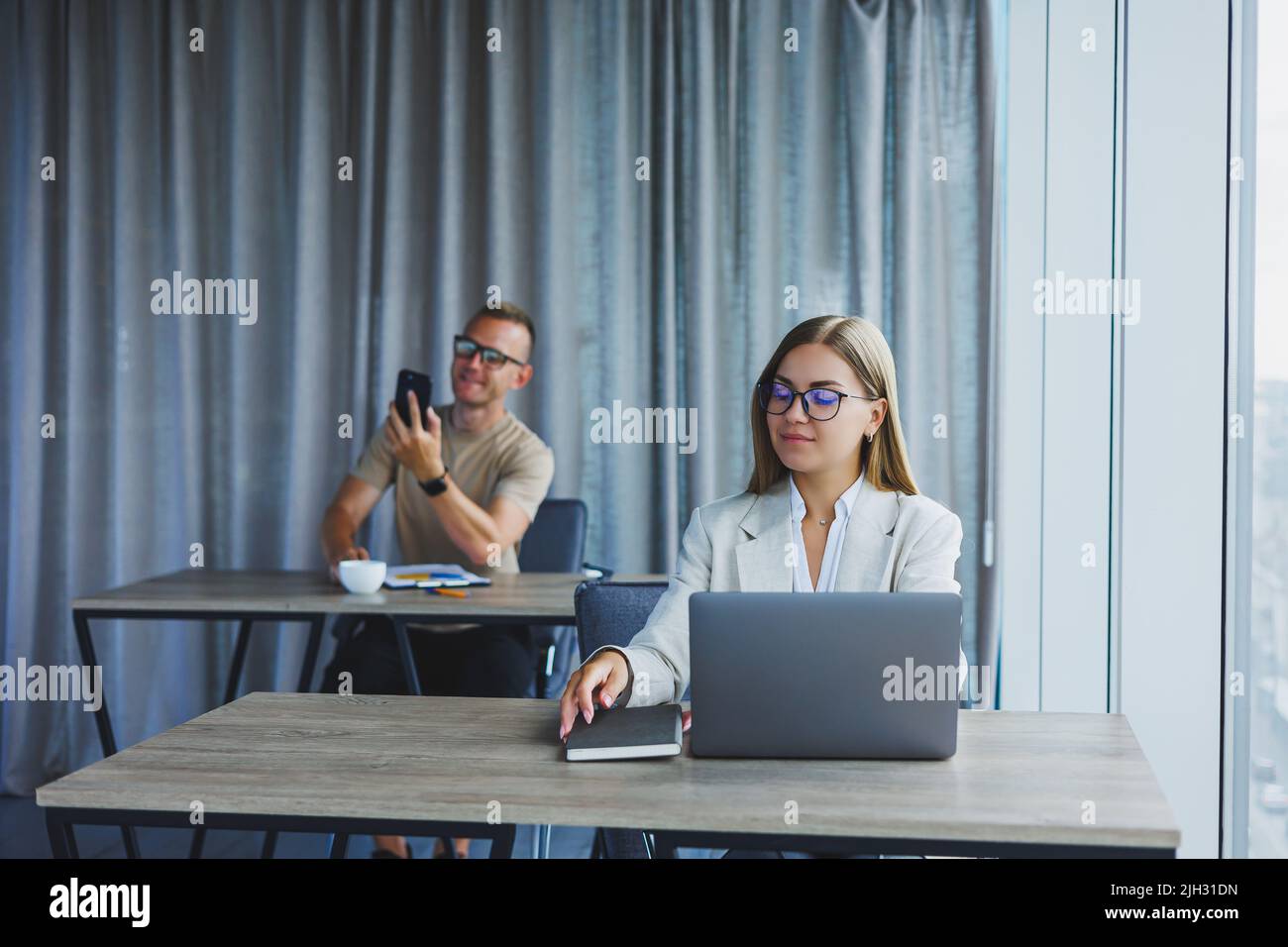 Woman with glasses at the table while working with colleagues in the ...
