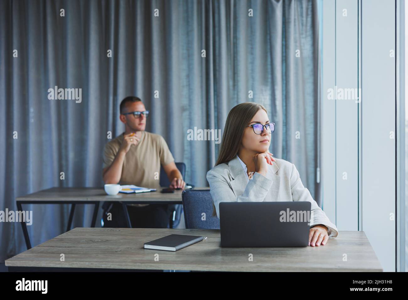 Woman with glasses at the table while working with colleagues in the ...