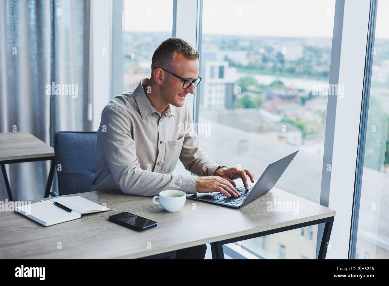 A businessman works on a laptop, a manager sits at a table in the ...