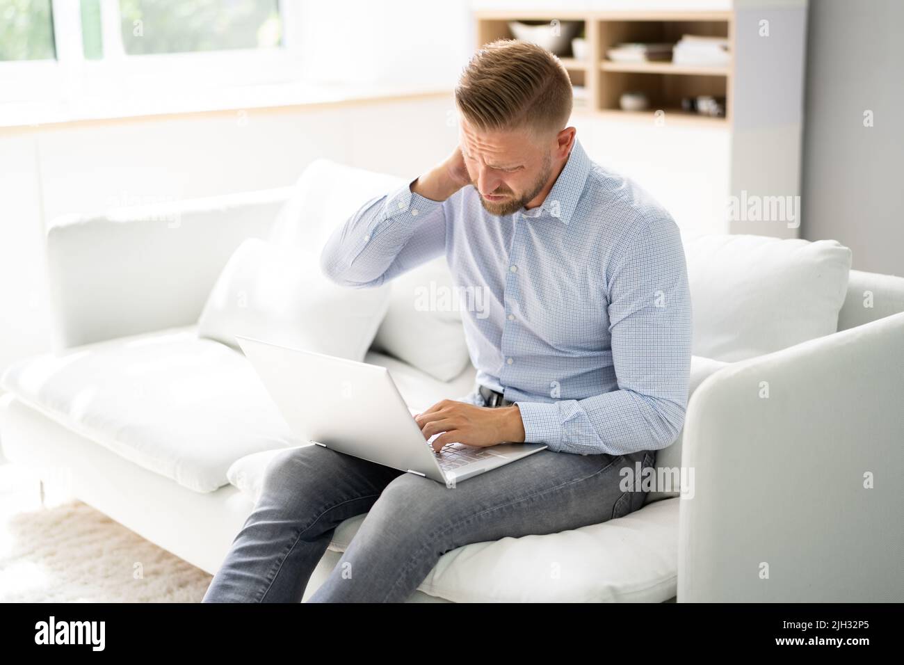 Neck Pain Bad Posture Man Sitting At Home Stock Photo - Alamy