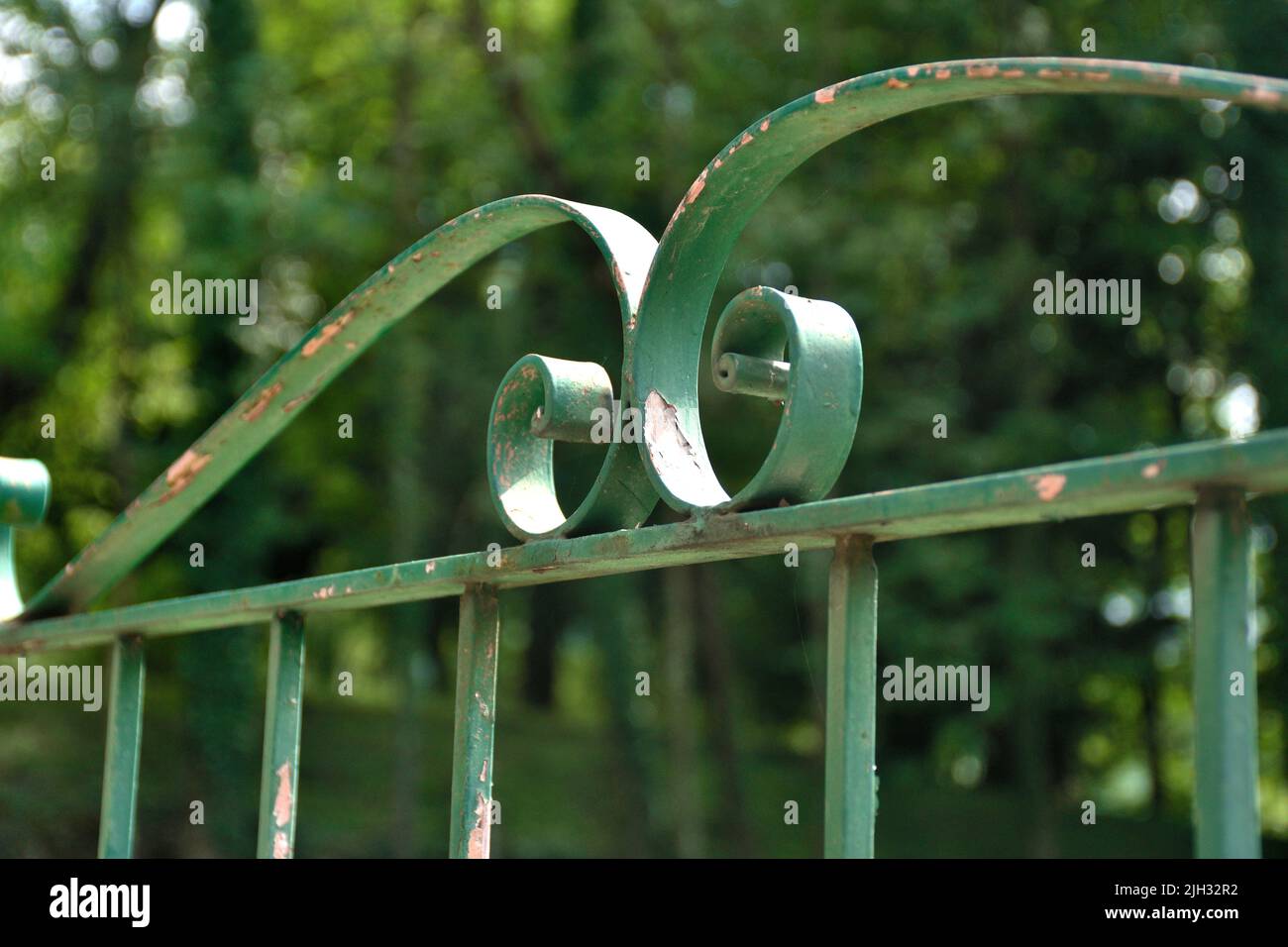 The top of a green gate in a blurred green background Stock Photo - Alamy