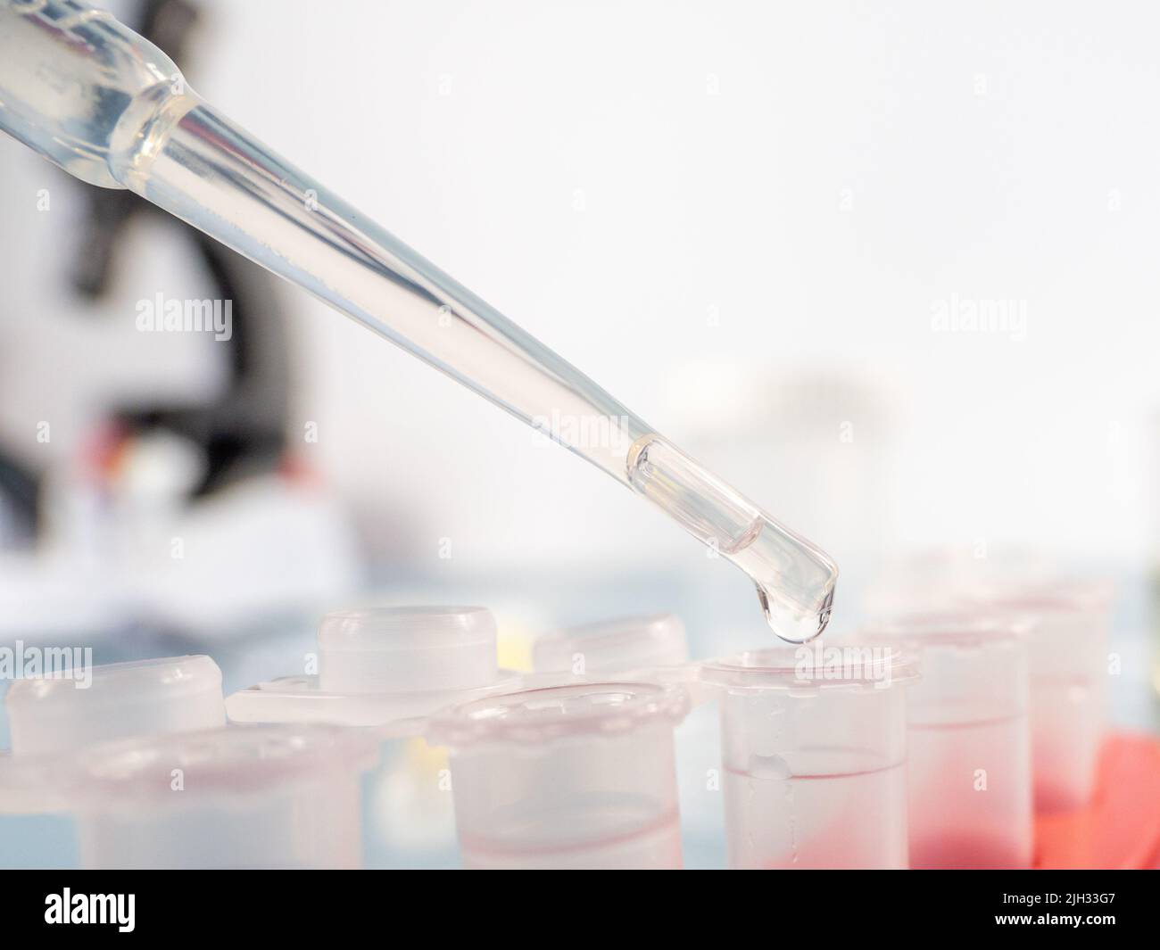Analytical chemistry - sample being pipetted into test tube for ...