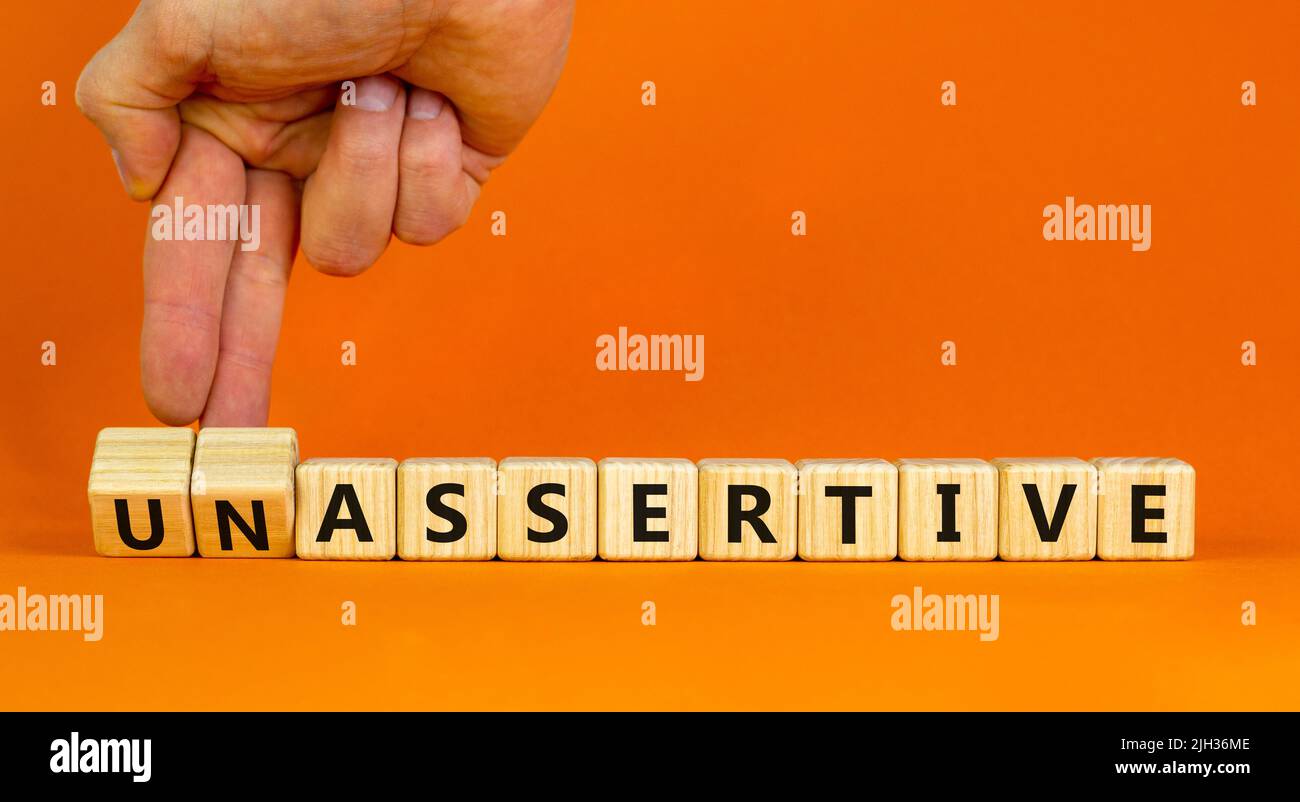 Assertive or unassertive symbol. Businessman turns wooden cubes and ...