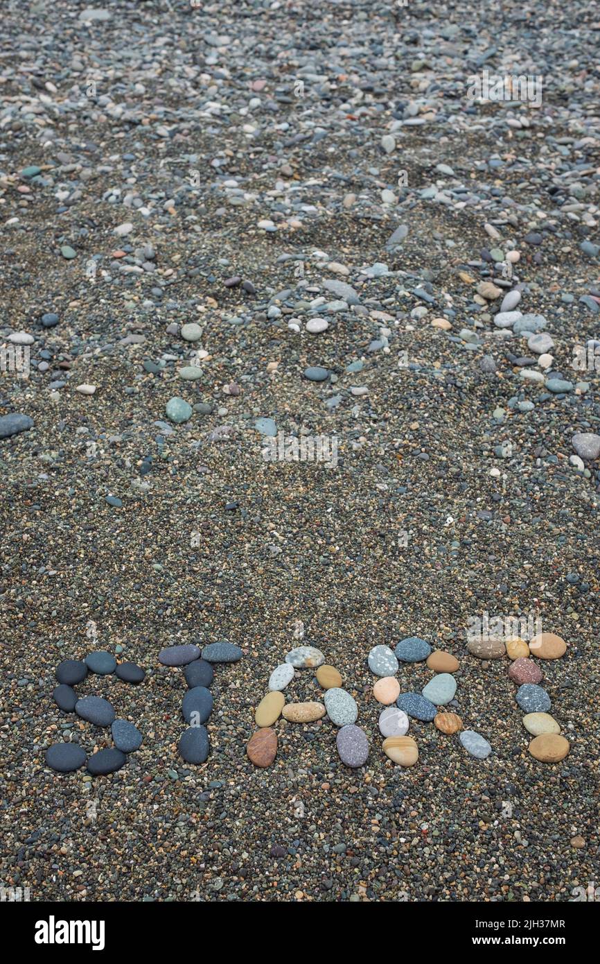 Word start made from stones on sandy beach. Vertical orientation Stock ...