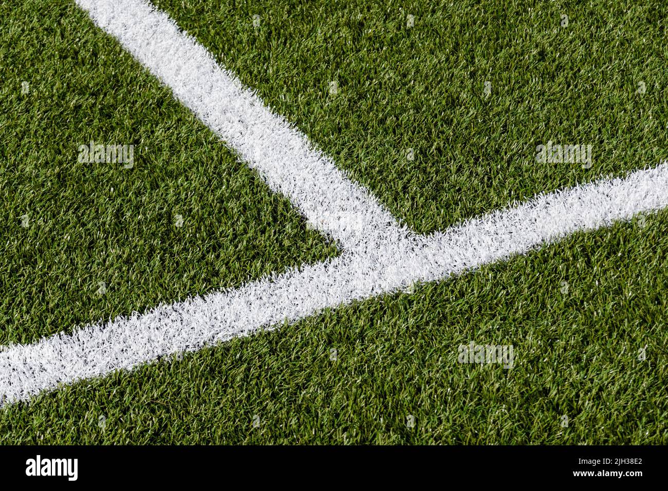 Green synthetic artificial grass soccer sports field with white corner ...