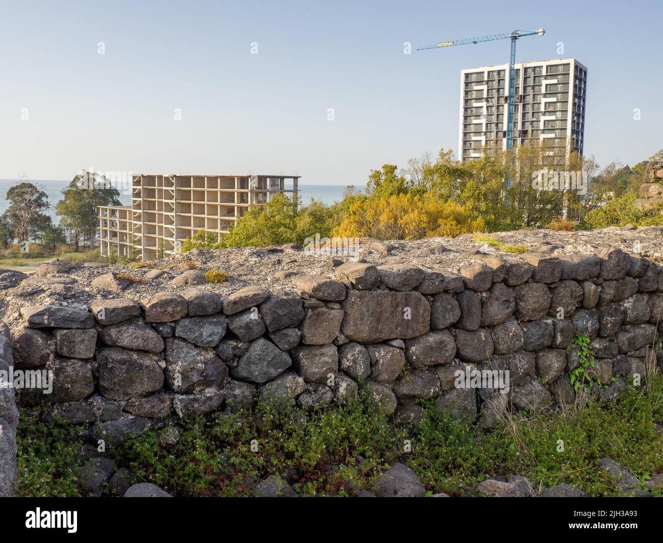 Construction of a modern house next to the ancient masonry. Old and new ...