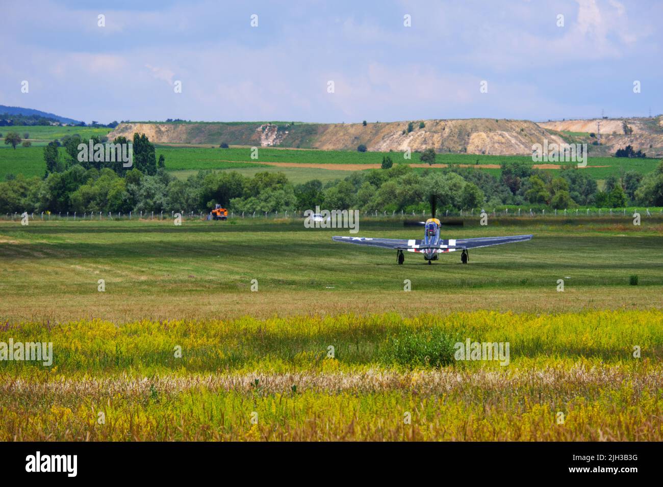 Small plane taking off from grass runway towards hills Stock Photo - Alamy