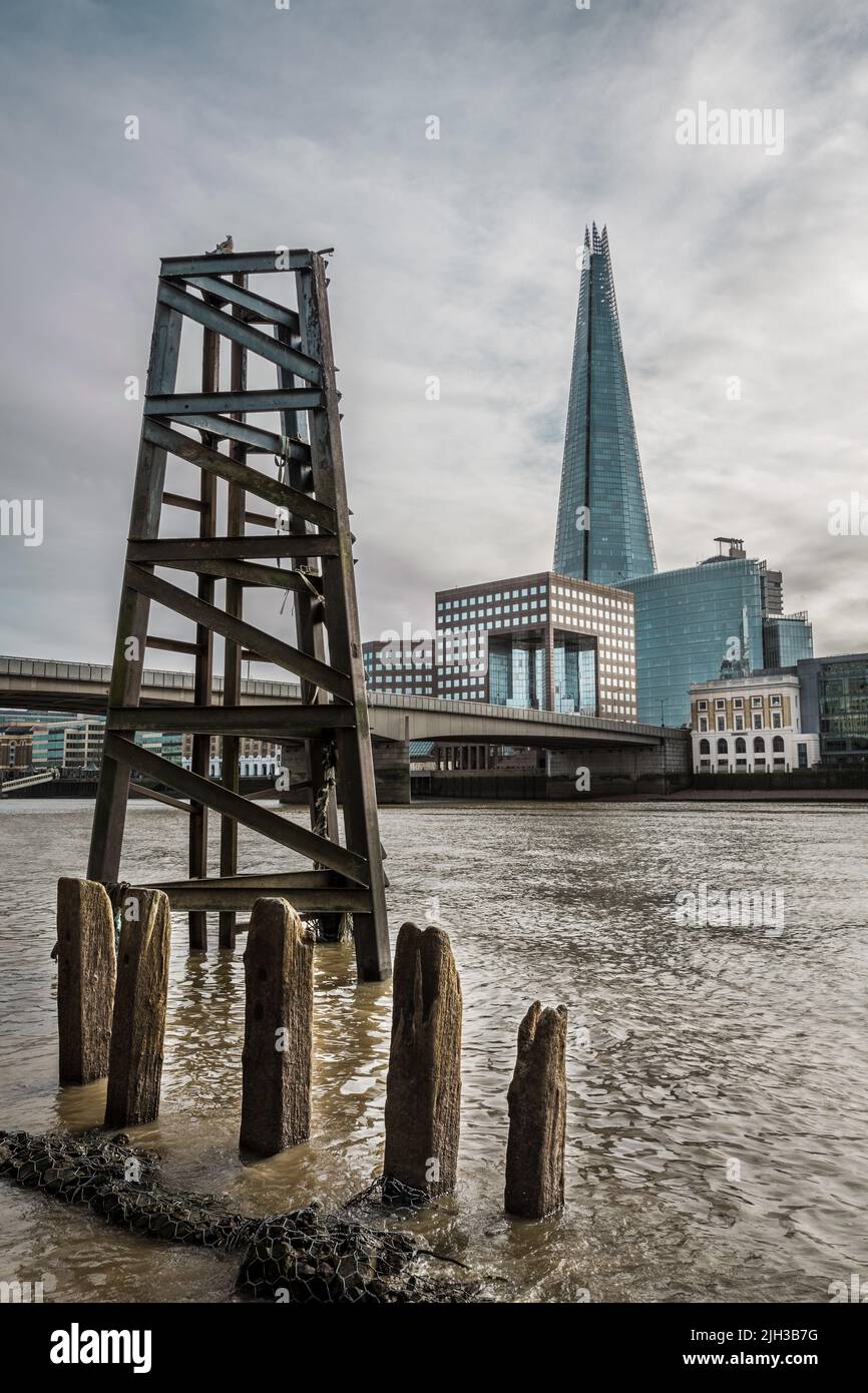 The Shard and London Bridge with an old pier support and wooden shoring ...